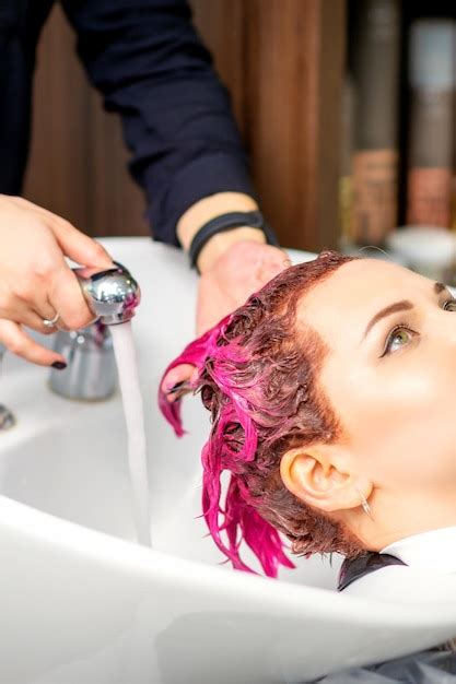 Lavando O Cabelo Feminino Tingido Uma Jovem Mulher Caucasiana Tendo O Cabelo Lavado Em Um Salão