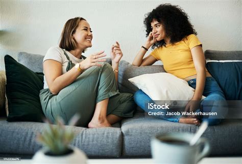 여성 친구들은 거실에서 가십 토론 및 행복으로 집에서 휴식을 취하고 대화를 나눕니다 소파에 앉아 미소를 짓고 소파에 앉아 있는