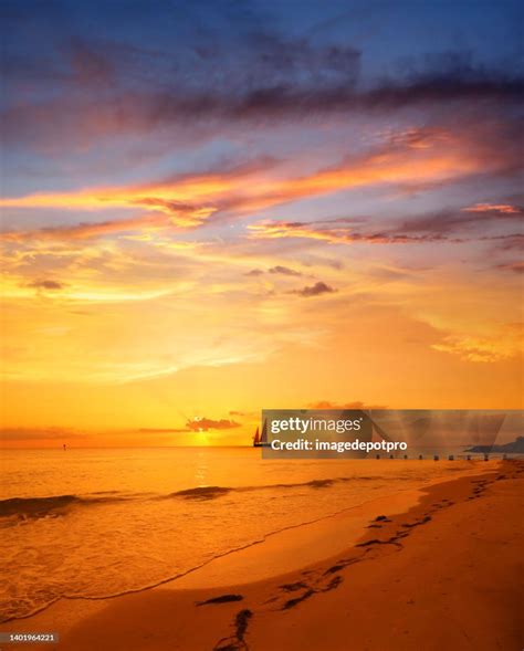 Orange Colored Seascape With Sailboat Over Sunset Sky High Res Stock