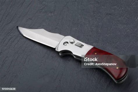 돌 표면에 칼 오픈 블레이드와 나무로 되는 손잡이 접는 철강 강철 무기입니다 무기 사냥 또는 범죄의 개념 0명에 대한 스톡 사진