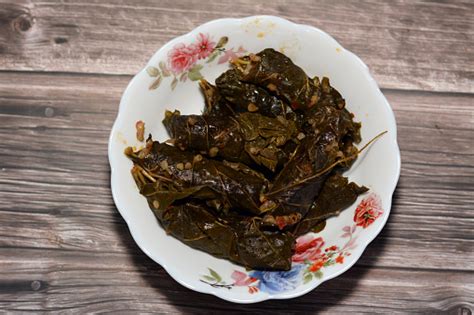 포장 된 포도 잎 한 접시는 이집트 Mahshi를 채우고 흰 쌀 양파 파슬리 딜 및 고수풀로 가득 차 있으며 Mahshy의 아랍 이집트 전통 요리의 선택적 초점이