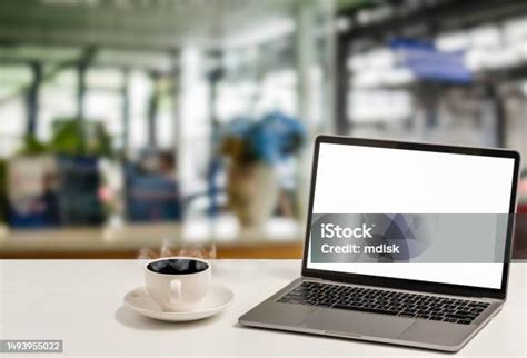 사무실의 흰색 책상 위에 빈 흰색 화면 노트북과 커피 컵이 놓여 있습니다 비즈니스 기술 인터넷 디자인 및 예술에 대한 개념입니다 근접 촬영 선택적 초점 흐릿한 배경 0명에
