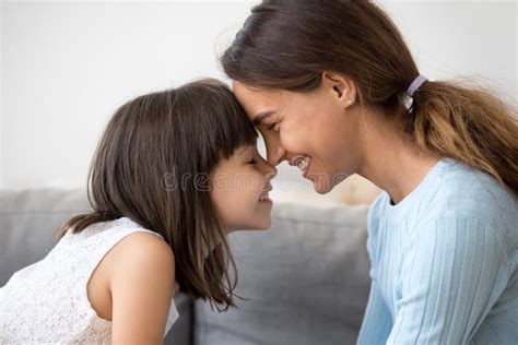 Mother And Daughter Touching With Foreheads Sitting On Couch Stock Photo Image Of Friend