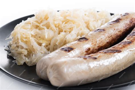 Salchichas Bratwurst Y Repollo Agrio Aislados Sobre Un Fondo Blanco