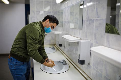 얼굴 마스크와 코로나 바이러스 남자 같은 질병을 피하기 위해 손을 씻는 남자는 공공 화장실에서 손을 씻는다 2020년에 대한 스톡 사진 및 기타 이미지 Istock