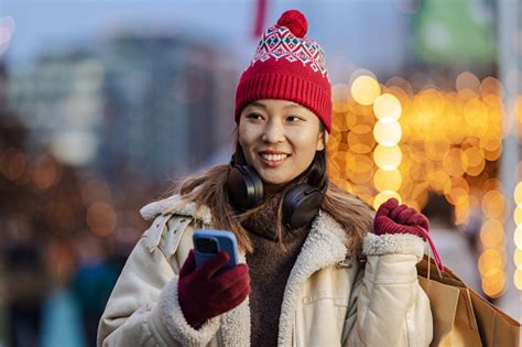 겨울 휴가 시즌에 야외에서 쇼핑하는 여성이 가방과 스마트폰을 들고 겨울에 대한 스톡 사진 및 기타 이미지 겨울 세일 12월 Istock