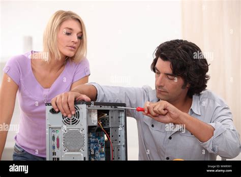 Man Fixing Computer With Woman Watching Stock Photo Alamy