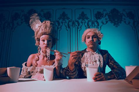 귀족 복장을 한 우아한 커플이 네온 조명이 있는 바로크 양식의 인테리어에서 현대적인 국수를 즐기고 있습니다 16 17 살에 대한 스톡 사진 및 기타 이미지 Istock