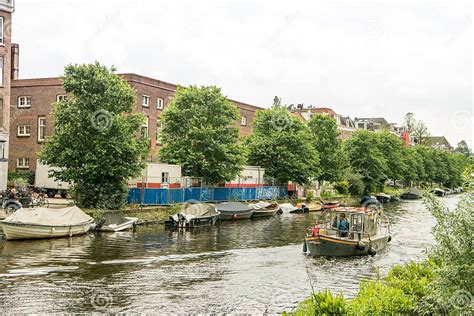 Iconic Dutch Canal Boats Plowing The Waters In Amsterdam Netherlands