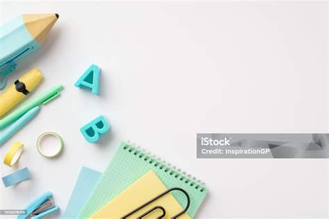 학교 개념으로 돌아 가기 학교 용품의 상단보기 사진 플라스틱 알파벳 글자 파란색 연필 케이스 메모 패드 접착 테이프 미니 스테이플러 마커와 펜은 빈 공간이있는 고립 된 흰색