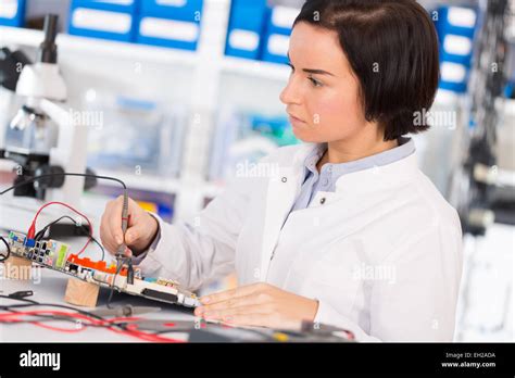 Woman With A Tester And A Printed Circuit Board Stock Photo Alamy