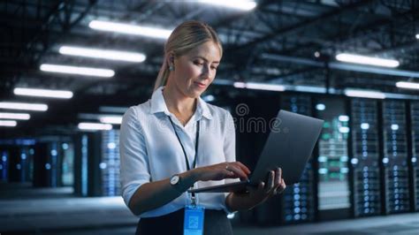 female engineer holding laptop computer at hands while programs