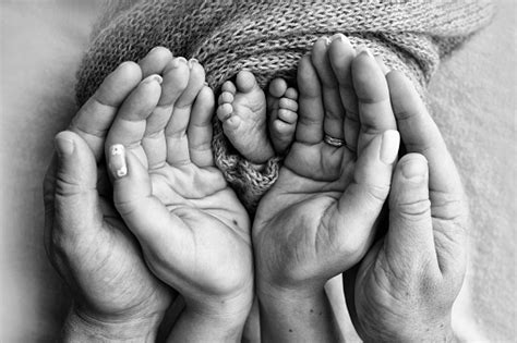 신생아의 다리 발가락 발 및 발 뒤꿈치 부모 아버지 어머니 여동생의 손으로 동생은 부드럽게 아이의 다리를 잡고 있습니다 흑백 사진 3 명에 대한 스톡 사진 및 기타 이미지