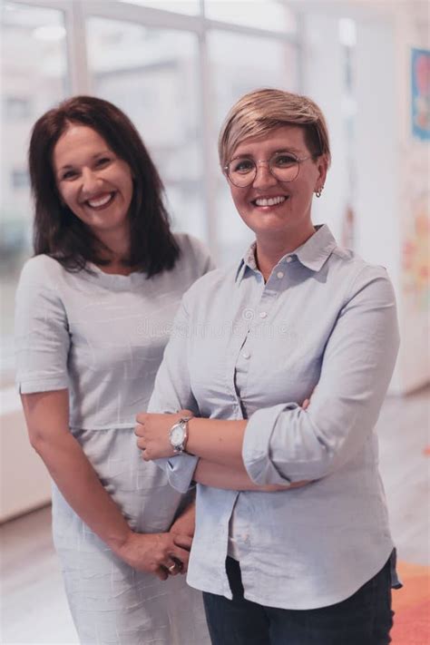 Portrait Of A Two Teacher In A Preschool Institution In The Background