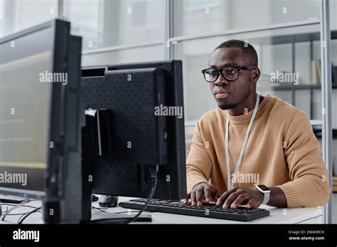 African American Programmer In Eyeglasses Concentrating On His Online