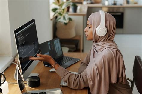 Premium Photo Young Muslim Female Programmer Pointing At Data On Computer Screen While Sitting