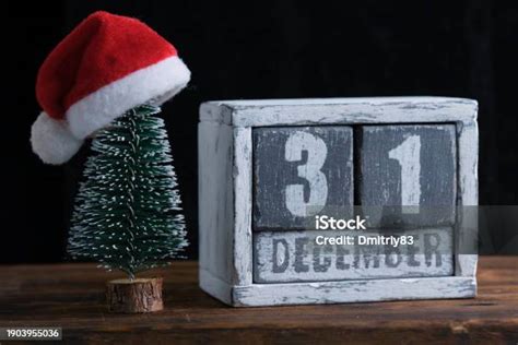 12 월 31 일 산타 클로스 모자로 장식 된 크리스마스 트리 옆에 서있는 나무 달력 0명에 대한 스톡 사진 및 기타 이미지 0명 12월 겨울 Istock