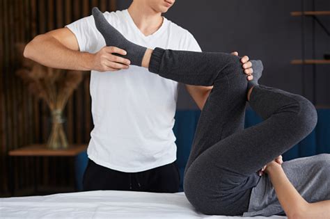 물리 치료사와 물리 운동을하는 여성 환자 젊은 선수의 부상 무릎을 치료 하는 남성 치료사 외상 후 재활 스포츠 물리 치료 회복 개념 강사에 대한 스톡 사진 및 기타 이미지