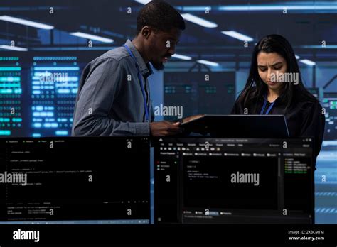 engineers in server farm checking recovery plan monitoring tech equipment energy consumption