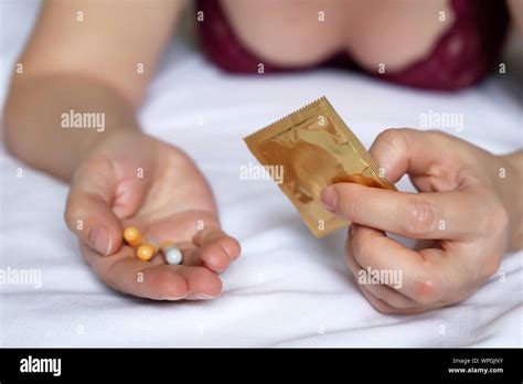 Safe Sex Choosing A Contraceptive Sexy Girl In Purple Bra Lying On The Bed With A Condom And