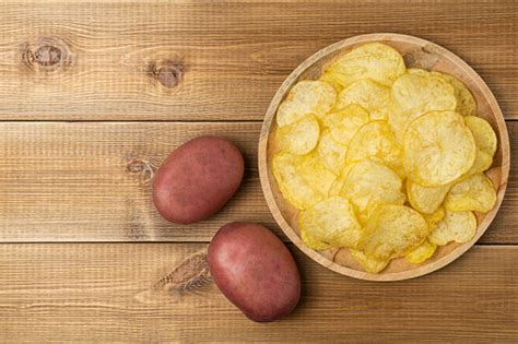나무 테이블에 원시 천연 유기농 감자와 맛있고 바삭바삭한 감자 칩 의 접시 상단 보기 0명에 대한 스톡 사진 및 기타 이미지 0명 감자 요리 감자 칩 Istock