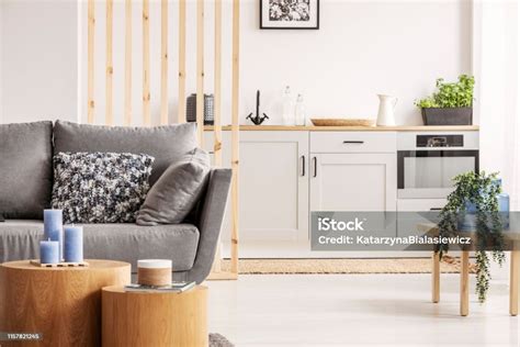 작은 흰색 주방과 회색 소파와 나무 커피 테이블이있는 거실이있는 벽으로 나뉘지 않은 오픈 플랜 스튜디오 아파트 부엌에 대한 스톡 사진 및 기타 이미지 Istock