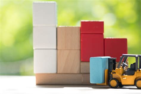 미니 포크 리프트 트럭 자연 녹색 배경으로 건물을 완료 하려면 파란색 나무 블록을 로드 합니다 산업 개념입니다 개념에 대한 스톡