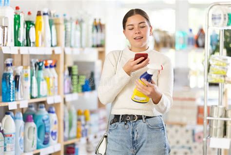 Before Making Purchase Girl Buyer Scan QR Code On Packaging Of Household Chemical Spray Stock