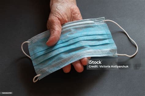 늙은 여자의 손은 어두운 배경에 일회용 의료 마스크를 들고 있다 2019년에 대한 스톡 사진 및 기타 이미지 2019년
