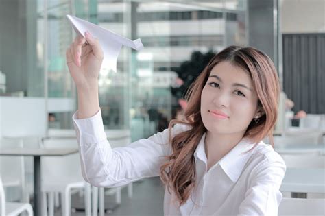 사무실에서 그녀의 손에 종이 비행기를 들고 매력적인 젊은 아시아 사업가의 초상화 비즈니스 비전 개념입니다 20 29세에 대한