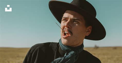 파란색과 흰색 스카프와 검은 모자를 쓴 검은 재킷을 입은 남자 사진 Unsplash의 무료 초상 이미지