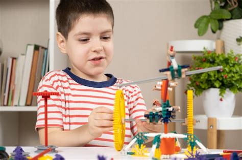 Premium Photo A Little Boy Plays With A Constructor Creating Figures