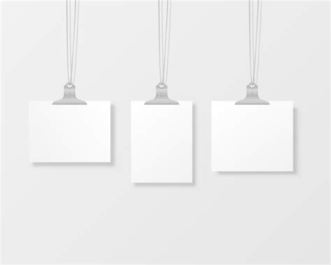 빈 교수형 사진 프레임 또는 배경에 고립 된 포스터 템플릿 벽에 바인더에 걸려있는 흰색 포스터 세트 한 장의 종이 프레임