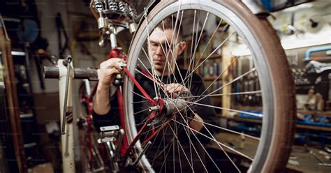 전문 청년이 작업장에서 자전거 뒷 바를 청소하고 있다 사진 Unsplash의 사람 이미지
