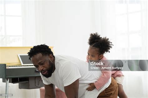 아프리카계 미국인 아버지와 귀여운 딸이 집에서 함께 놀고 있습니다 성인 아빠와 어린 딸이 집에서 함께 시간을 보냅니다 아버지 딸 그리고 가족 개념 검은색에 대한 스톡 사진