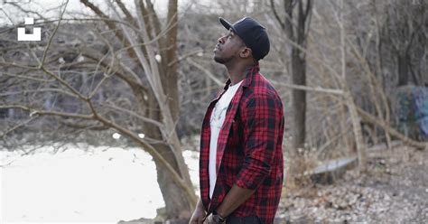 빨간색과 흰색 격자 무늬 드레스 셔츠와 파란색 데님 청바지를 입은 남자가 갈색 나무 근처에 서 있습니다 사진 Unsplash의 무료 회색 이미지