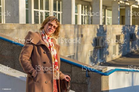 석양에 이른 봄에 사무실 건물의 계단에 가방에 서 있는 세련 된 코트를 입고 매력적인 중 년 여성 스트리트 시티 초상화 패션 도시 복장 가방에 대한 스톡 사진 및 기타