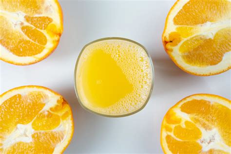 갓 짜낸 오렌지 주스를 옆에 오렌지 조각이 있는 테이블 위에 잔에 담습니다 흰색 배경에 과일과 상쾌한 노란색 음료 0명에 대한 스톡 사진 및 기타 이미지 Istock