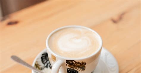 Froth Art 도자기 컵 따뜻한 따뜻한 음료 라떼 아트 러스틱 모닝 커피 목조 테이블 바리스타 빈티지 컵 셀렉티브 포커스 수직 쐈어 숟가락 술을