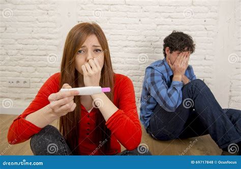 Young Sad Couple Scared In Shock And Surprise Reading Pink Positive