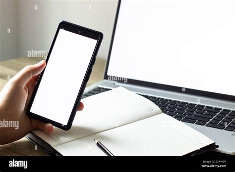 Blank White Screens Of Mobile Phone And Laptop Man Holding Phone In