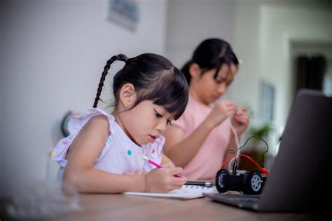 아시아 학생들은 Stem에서 로봇 자동차와 전자 보드 케이블을 코딩하여 집에서 배웁니다 Steam 수학 공학 과학 기술 어린이 개념을 위한 로봇 공학에서 컴퓨터 코드