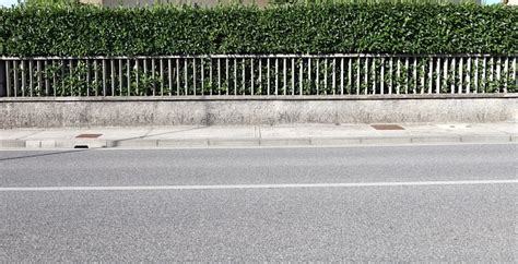 콘크리트 난간이 있는 긴 벽으로 구성된 집 울타리 뒤에서 헤지하십시오 시멘트 보도와 아스팔트 거리 앞 0명에 대한 스톡 사진 및 기타 이미지 Istock