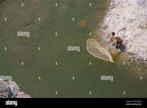 Pescador Tradicional De La Pesca Que Lanza La Red En El Río Para