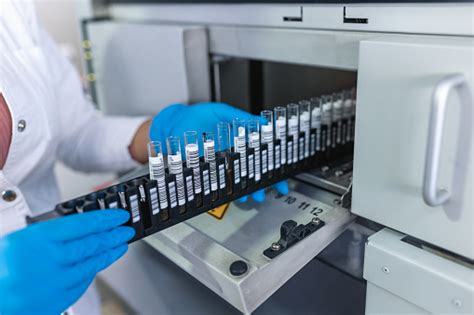 기계에서 혈액 샘플 시험관을 보고 있는 의사 손의 클로즈업 테스트 실험실에서 작업하는 보호 장갑을 낀 알아볼 수 없는 과학자 손의 잘린 사진 개체 그룹에 대한 스톡 사진 및