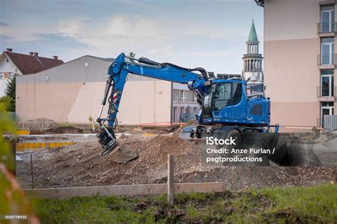 도시의 건설 현장에 굴삭기 또는 굴착기 건물의 바닥판을 만드는 동안 흙이나 자갈 더미 위에 쉬고 있는 파란색 굴착기 0명에 대한 스톡 사진 및 기타 이미지 Istock