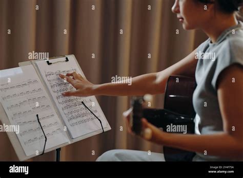 Playing Acoustic Guitar While Reading Music Notes Stock Photo Alamy