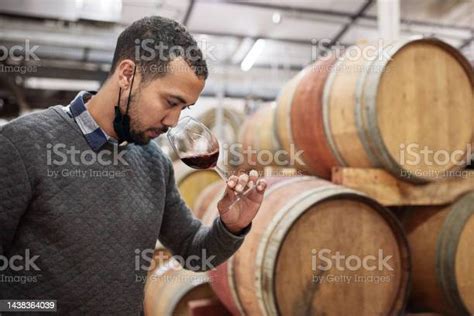 창고의 지하실이나 증류소에서 시음 테스트 중 유리를 가진 와인 전문가 또는 기업가 제조 와이너리 안에 나무 통이 있는 알코올 생산 저장고의 농업 노동자 와인에 대한 스톡