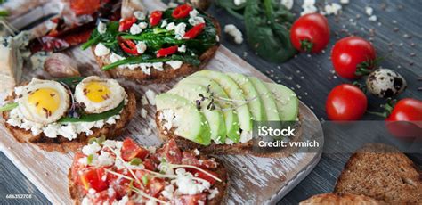 맛있고 맛 있는 브루 쉐 타 토마토 시금치 아보카도 Feta 빨강 칠리 페 퍼와 블루 치즈 마이크로 녹색 참 깨 씨 및 아마 건강 한 먹는 개념 구운 식품에 대한 스톡 사진