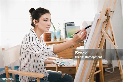 젊은이 아름 다운 아시아 여성 예술가 그림 수채화 예술 그림 실내 스튜디오 초상화 사진 밝고 아늑한 스튜디오에서 캔버스에 그림을 그리는 젊은 아시아 여성 공예에 대한 스톡